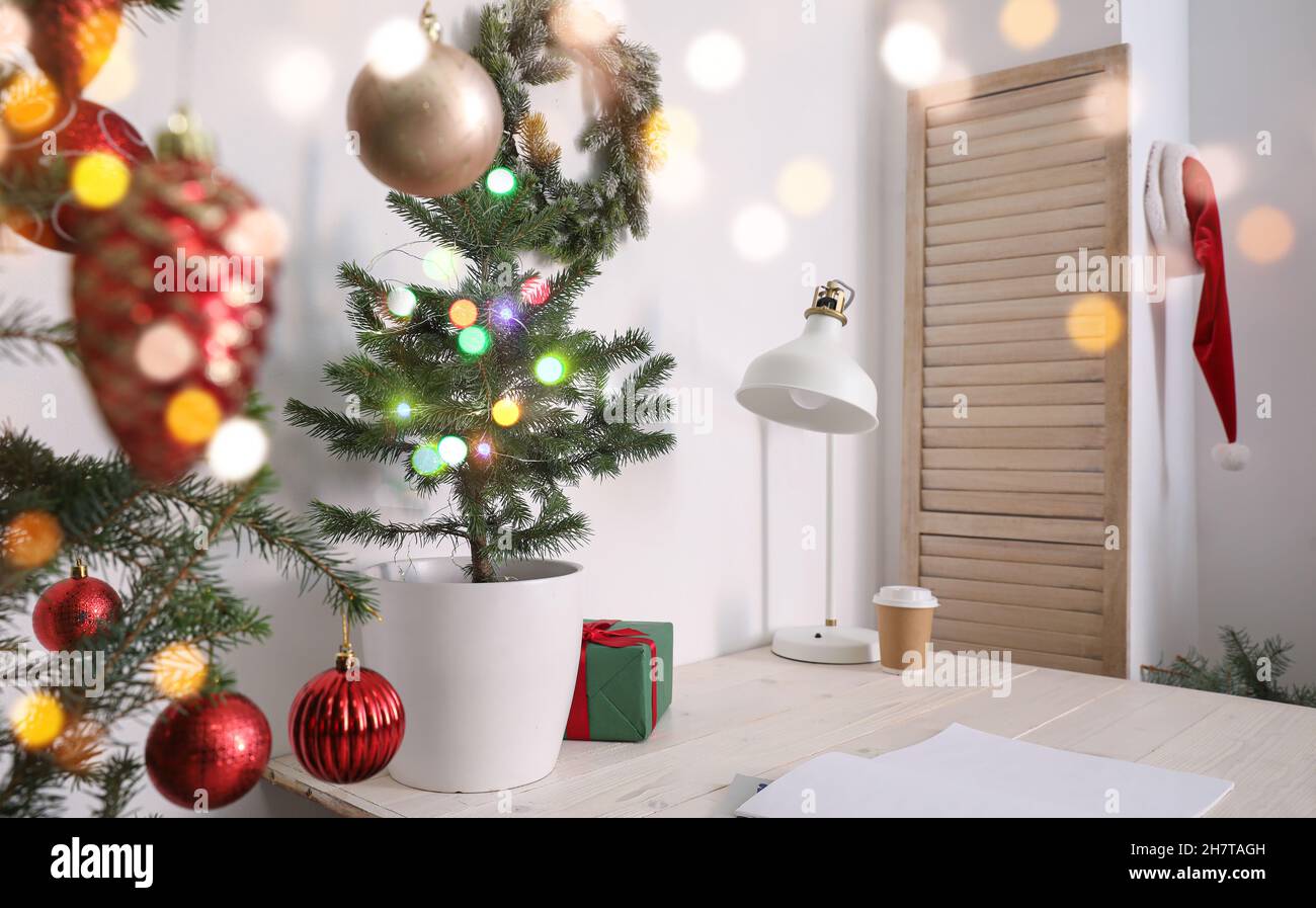 Workplace with beautiful Christmas tree in room Stock Photo - Alamy