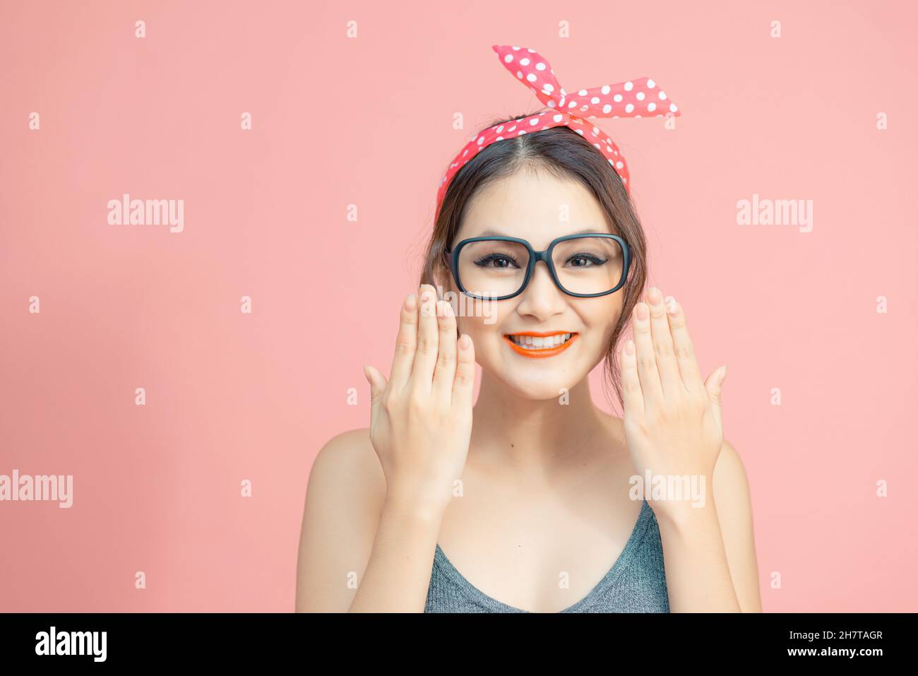Pretty lady hold palm hands near cheeks isolated on pink background ...