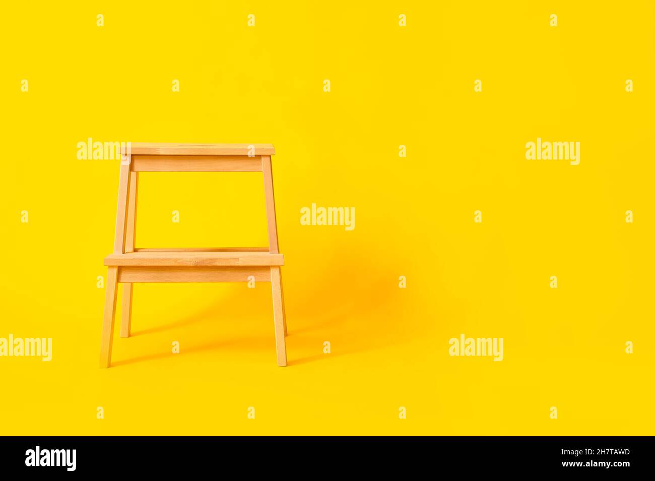 Wooden step stool on yellow background Stock Photo - Alamy