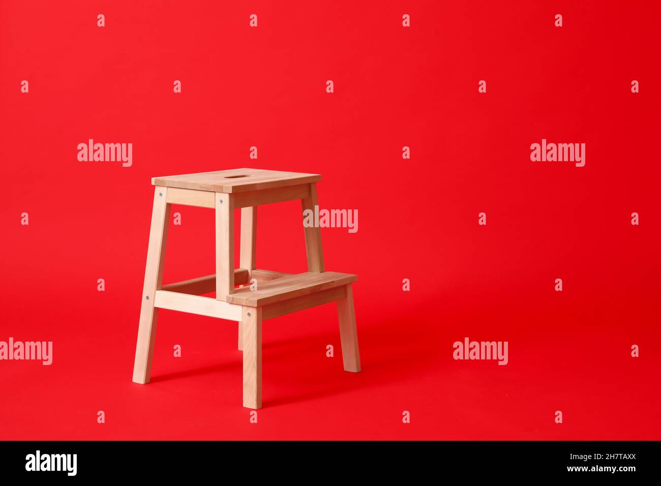 Wooden step stool on red background Stock Photo - Alamy