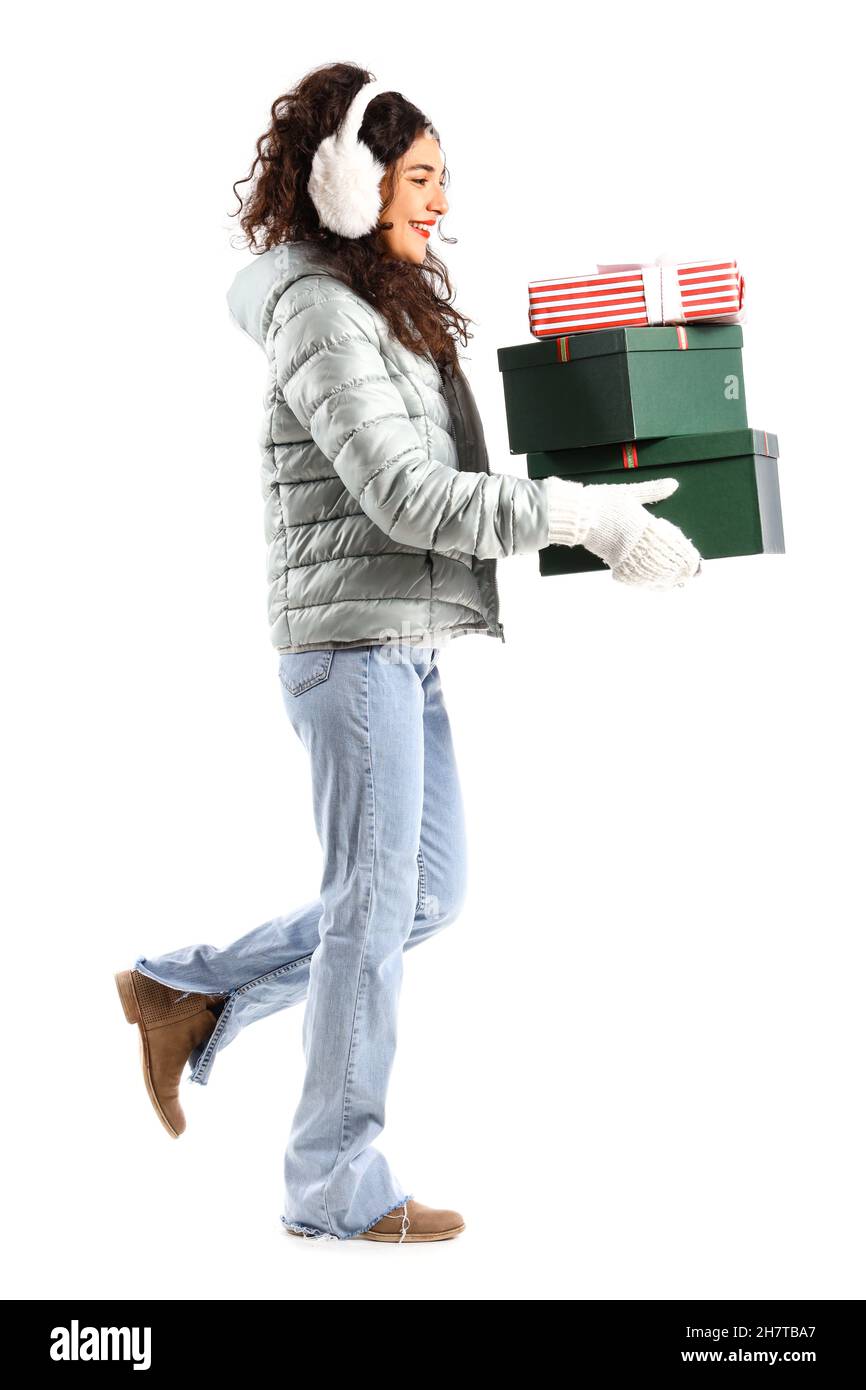Beautiful walking young woman with Christmas gifts on white background ...