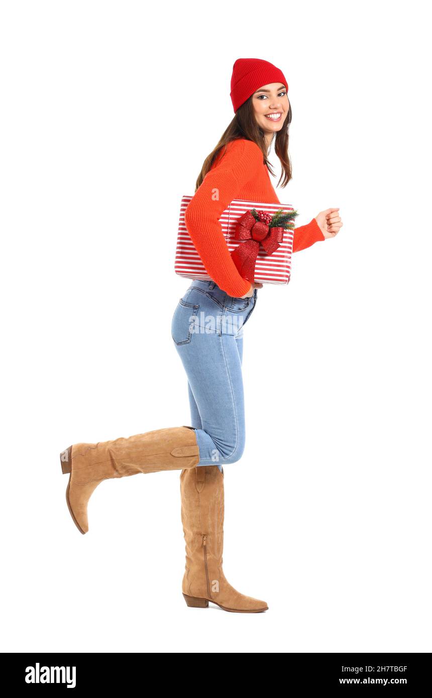 Beautiful walking young woman with Christmas gift on white background ...