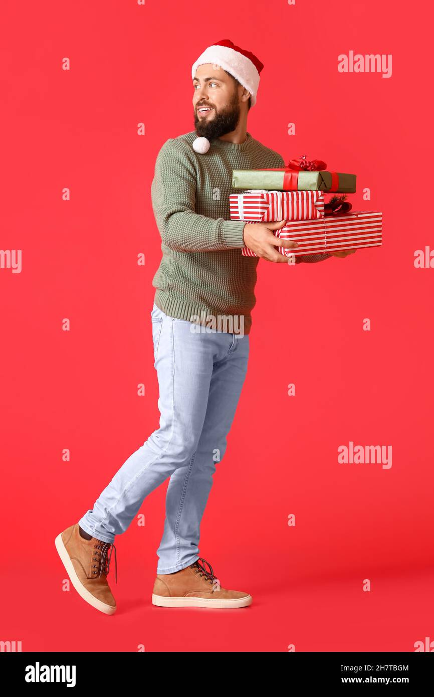 Walking man with Christmas gifts on color background Stock Photo - Alamy