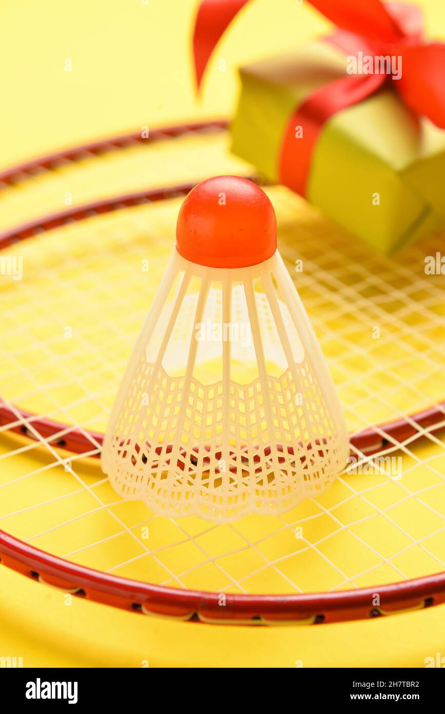 Badminton rackets, shuttlecock and Christmas gift on color background ...