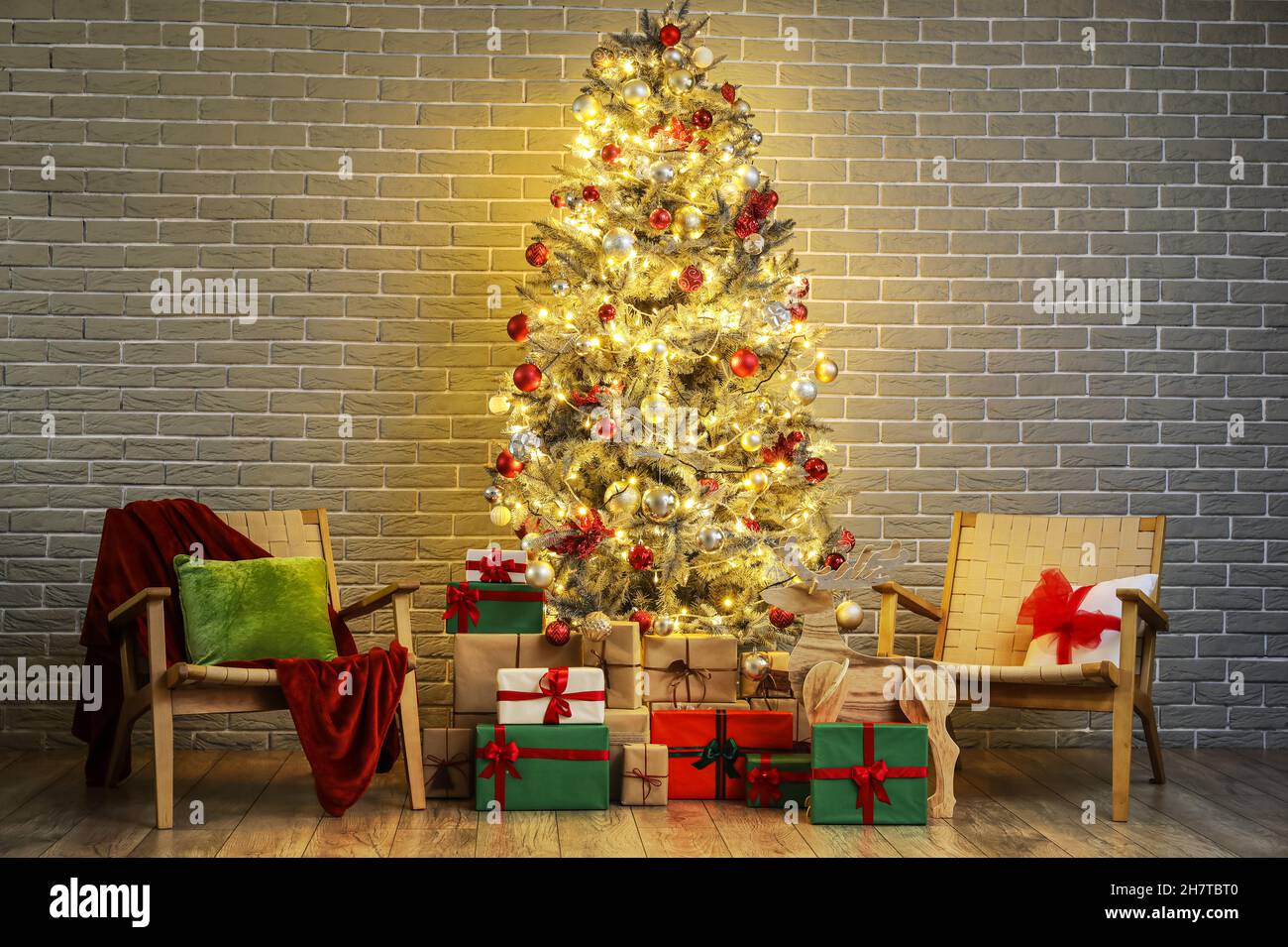 Beautiful Christmas tree with glowing lights, gifts and chairs near ...