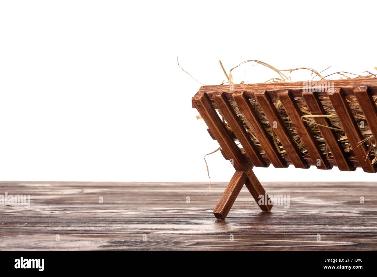 Wooden manger with hay on table against white background Stock Photo ...