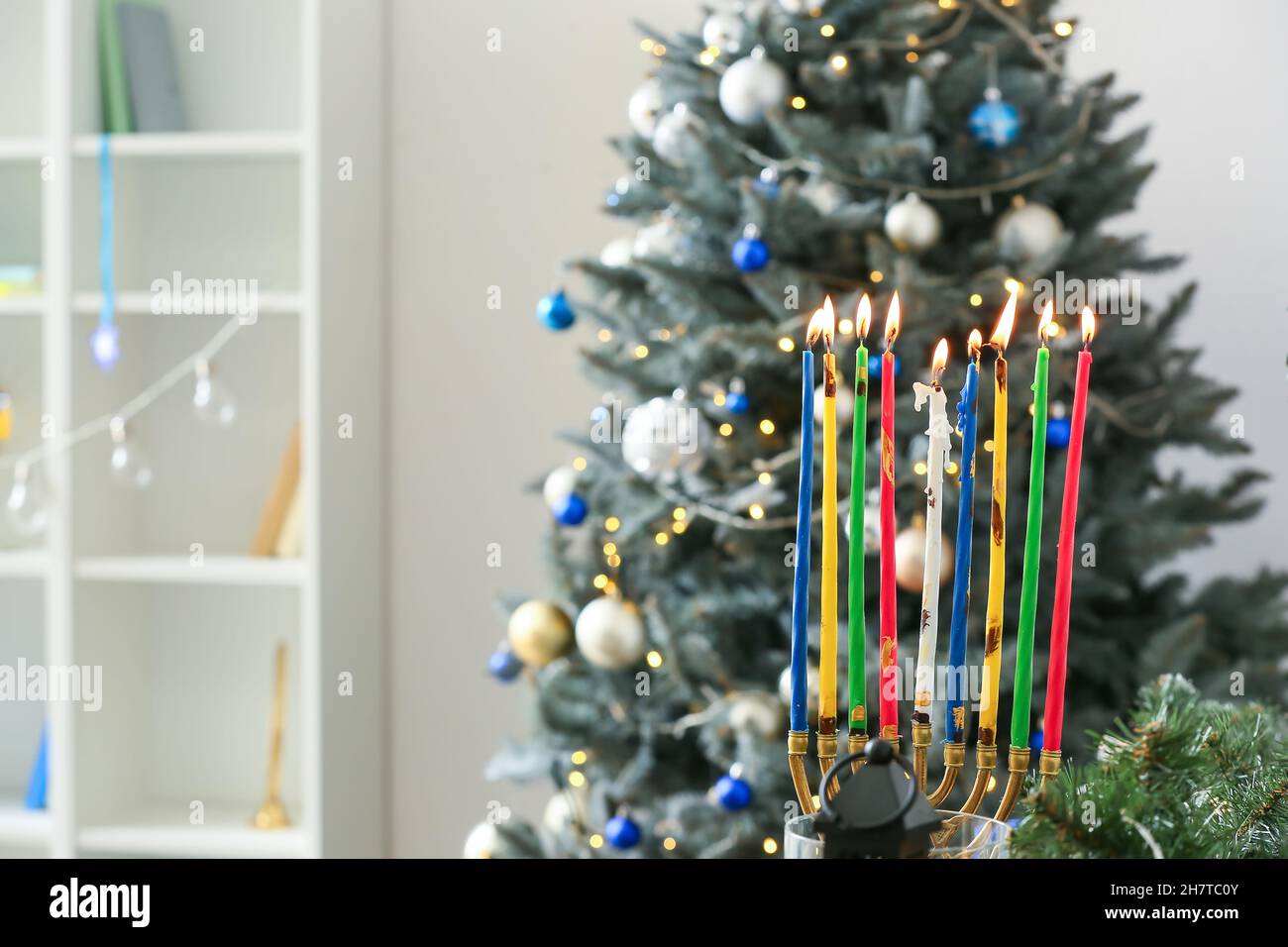 Menorah for Hanukkah celebration and Christmas tree in room Stock Photo ...