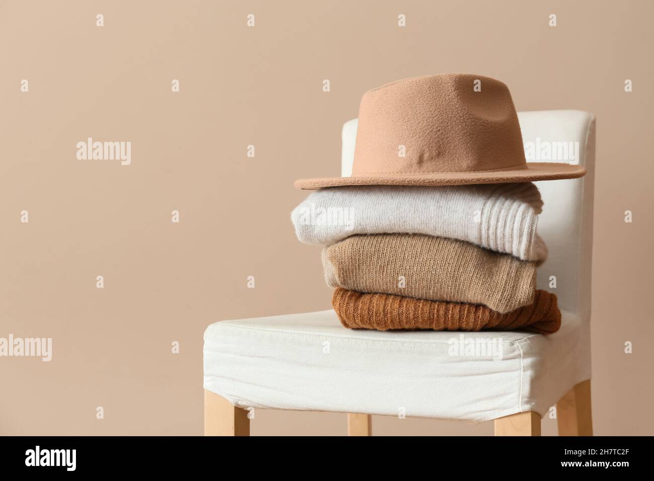 Stylish winter clothes on chair against light background Stock Photo ...