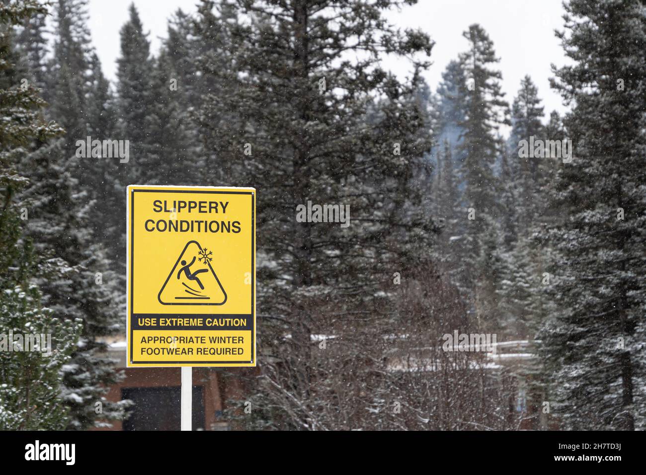 Slippery conditions warning sign in national park during snowfall Stock ...
