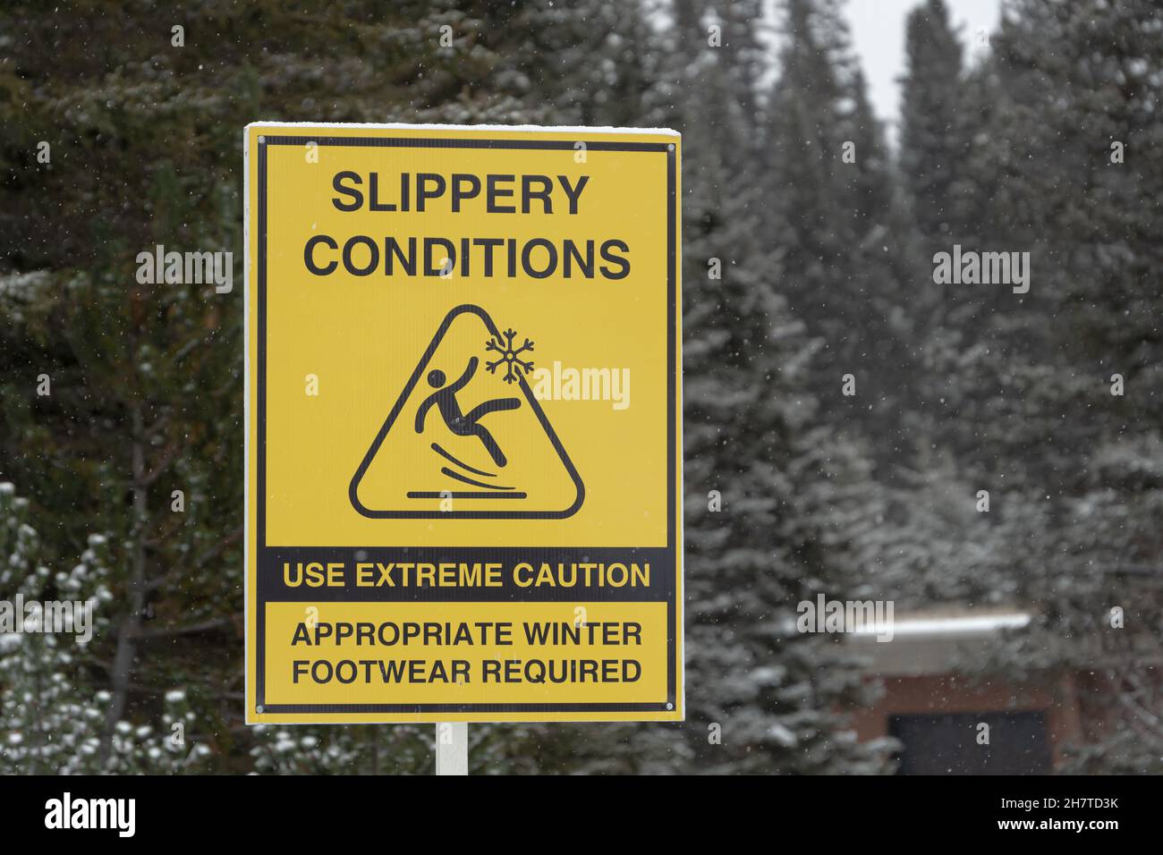 Slippery conditions warning sign in national park during snowfall Stock ...