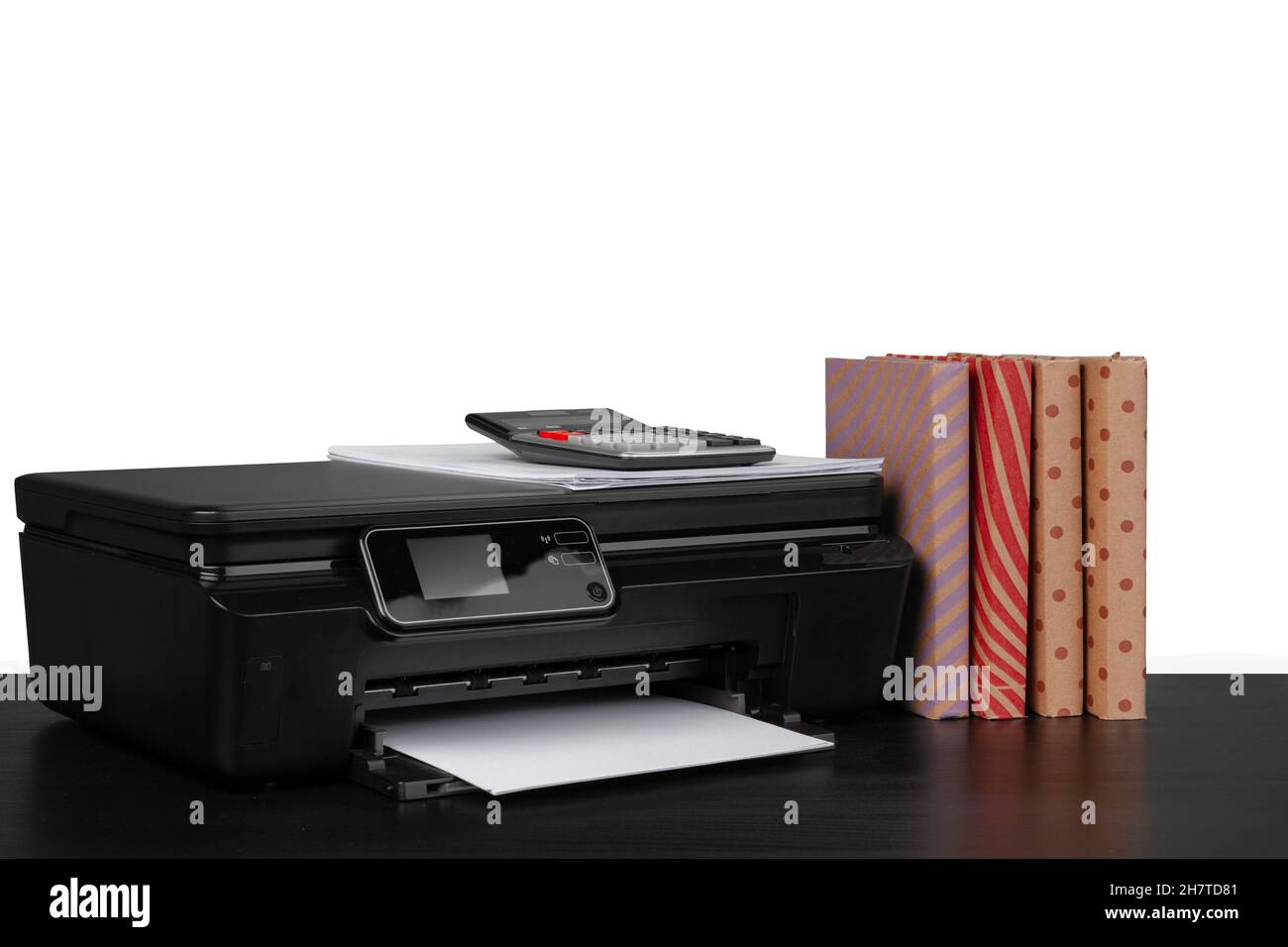 Printer and stack of books on black table against white background ...