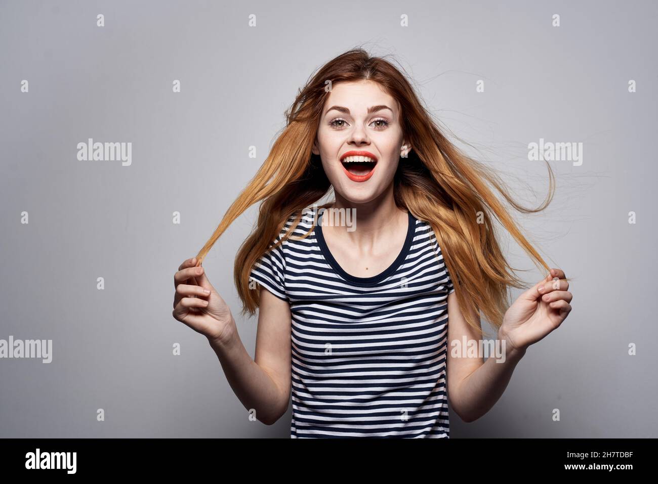 cheerful woman holding hair makeup posing fun fashion model studio ...