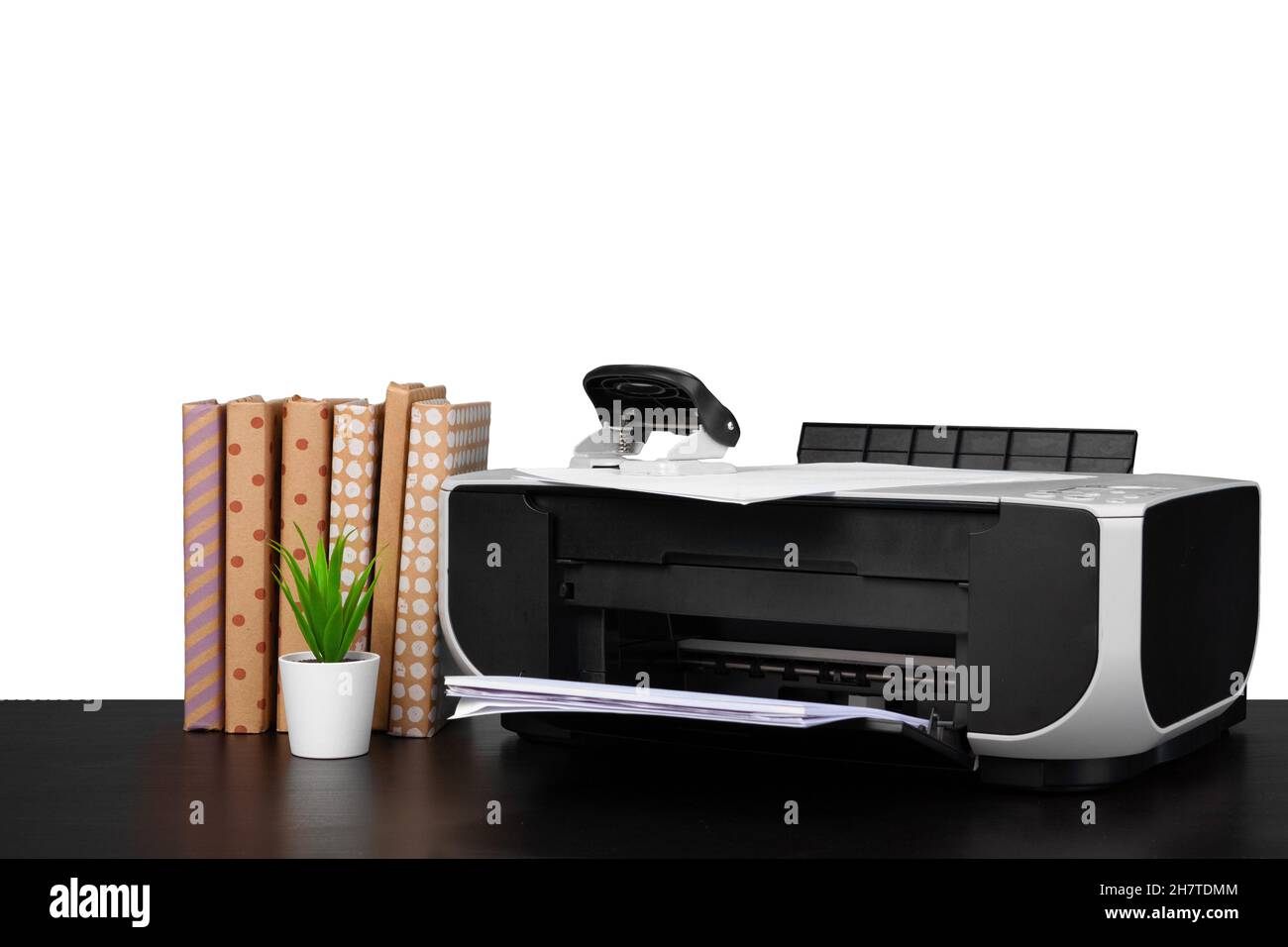 Printer and stack of books on black table against white background ...