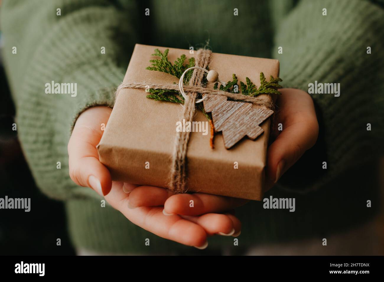 Female hands holding nice gift box. Woman giving wrapped in black paper ...