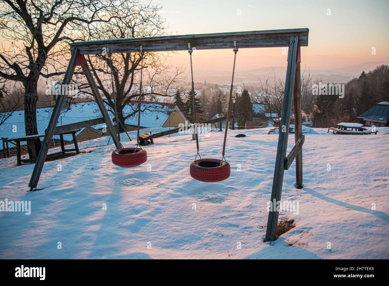 The children's playground is covered with snow and is empty on a cold ...