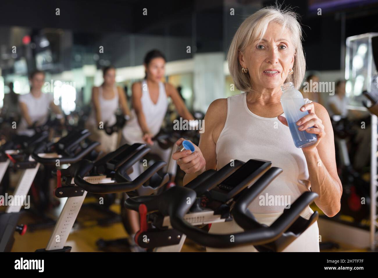 Woman drinking water during workout in gym Stock Photo - Alamy