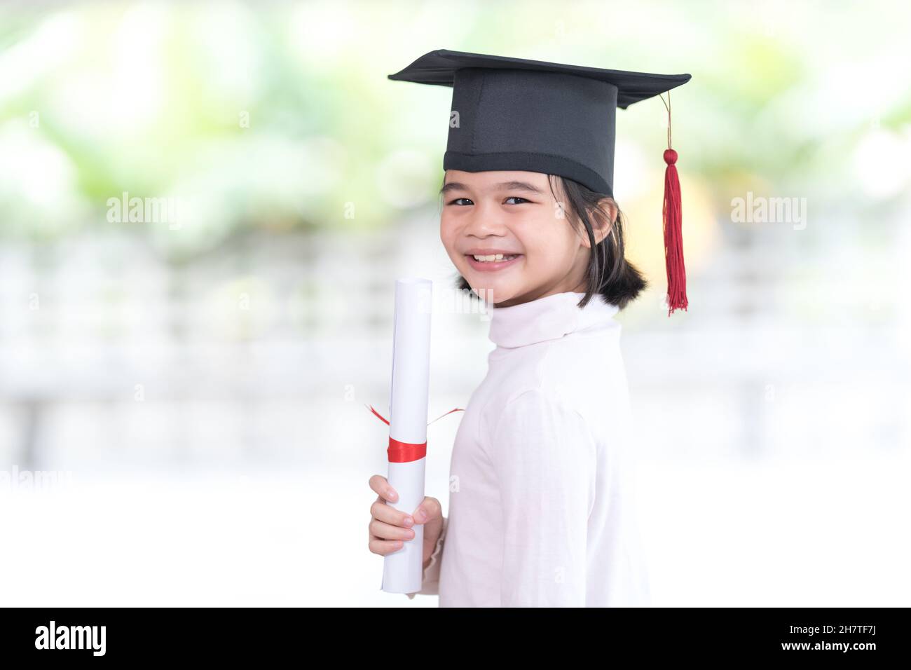 Happy Southeast Asian female schoolkid with a certificate celebrating ...