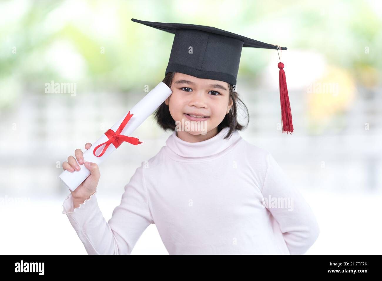 Happy Southeast Asian schoolgirl with a certificate celebrating ...