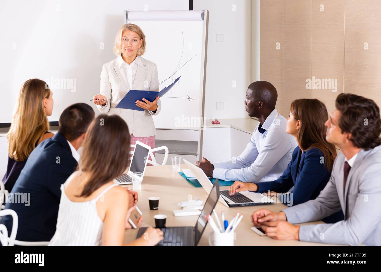 Woman making presentation on staff meeting Stock Photo - Alamy