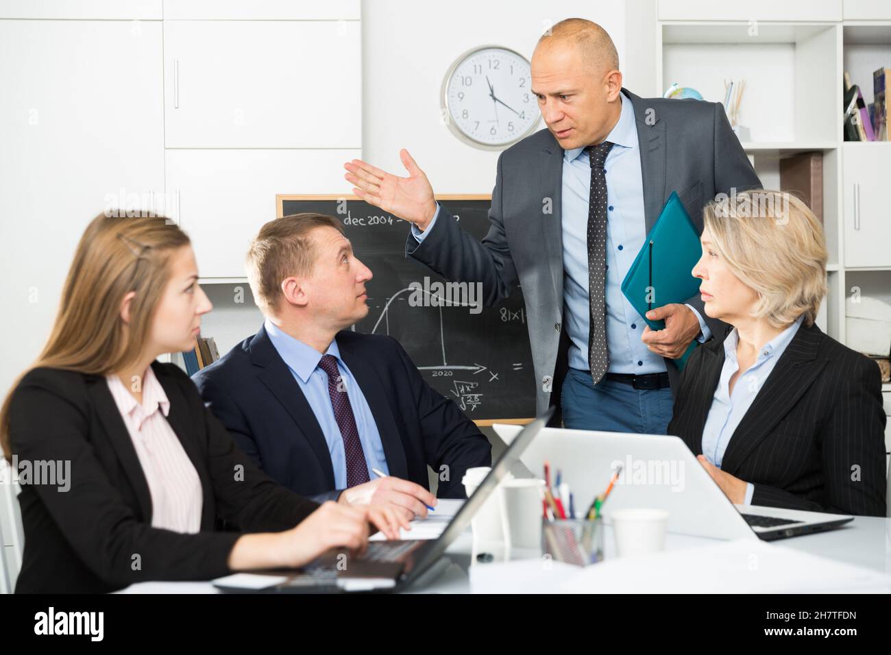 Businessman feeling angry to coworkers in office Stock Photo - Alamy