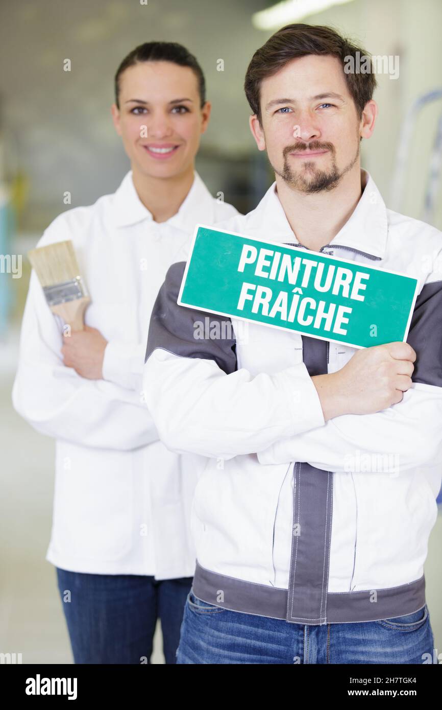 female and male painter holding a wet sign Stock Photo - Alamy