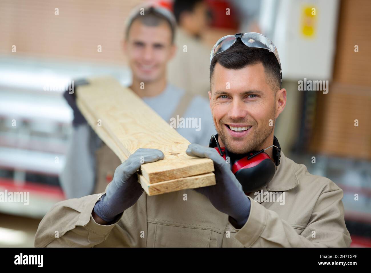 woodworking workers carrying plank of wood Stock Photo - Alamy