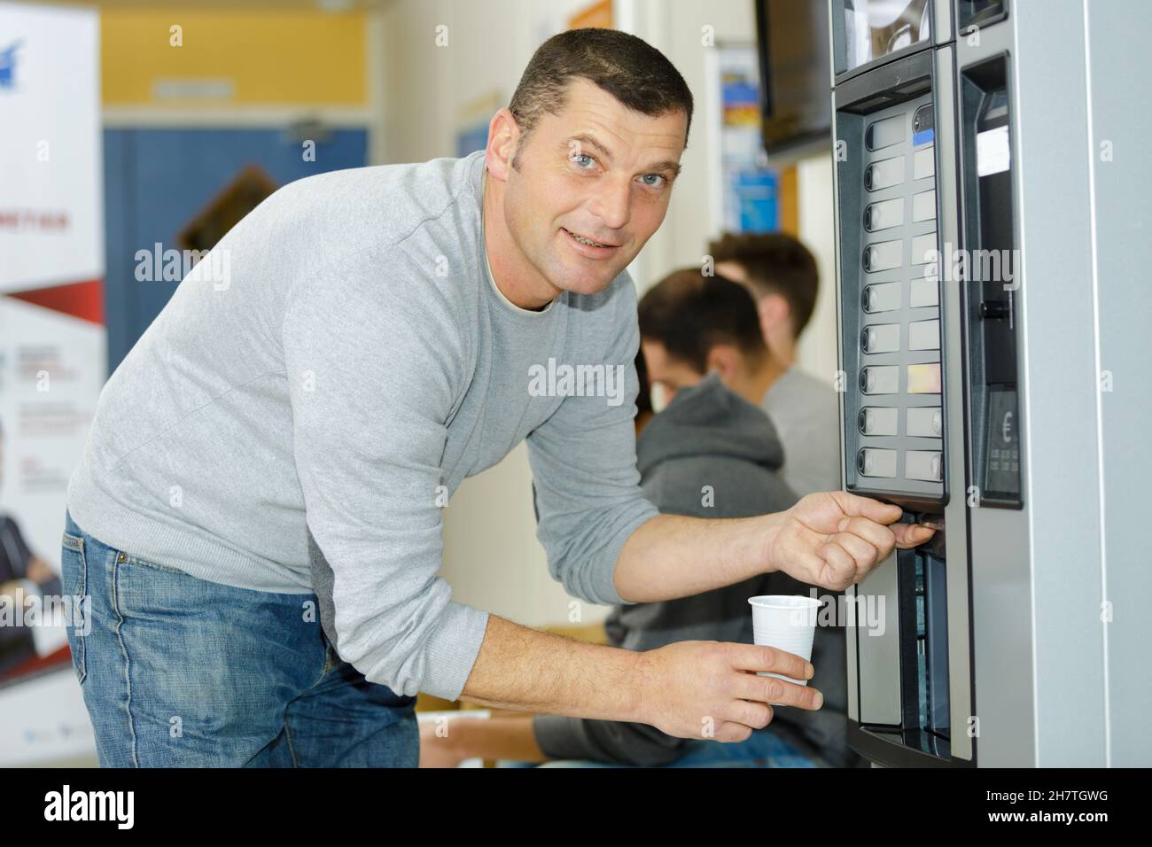 man getting drink from vending machine Stock Photo - Alamy
