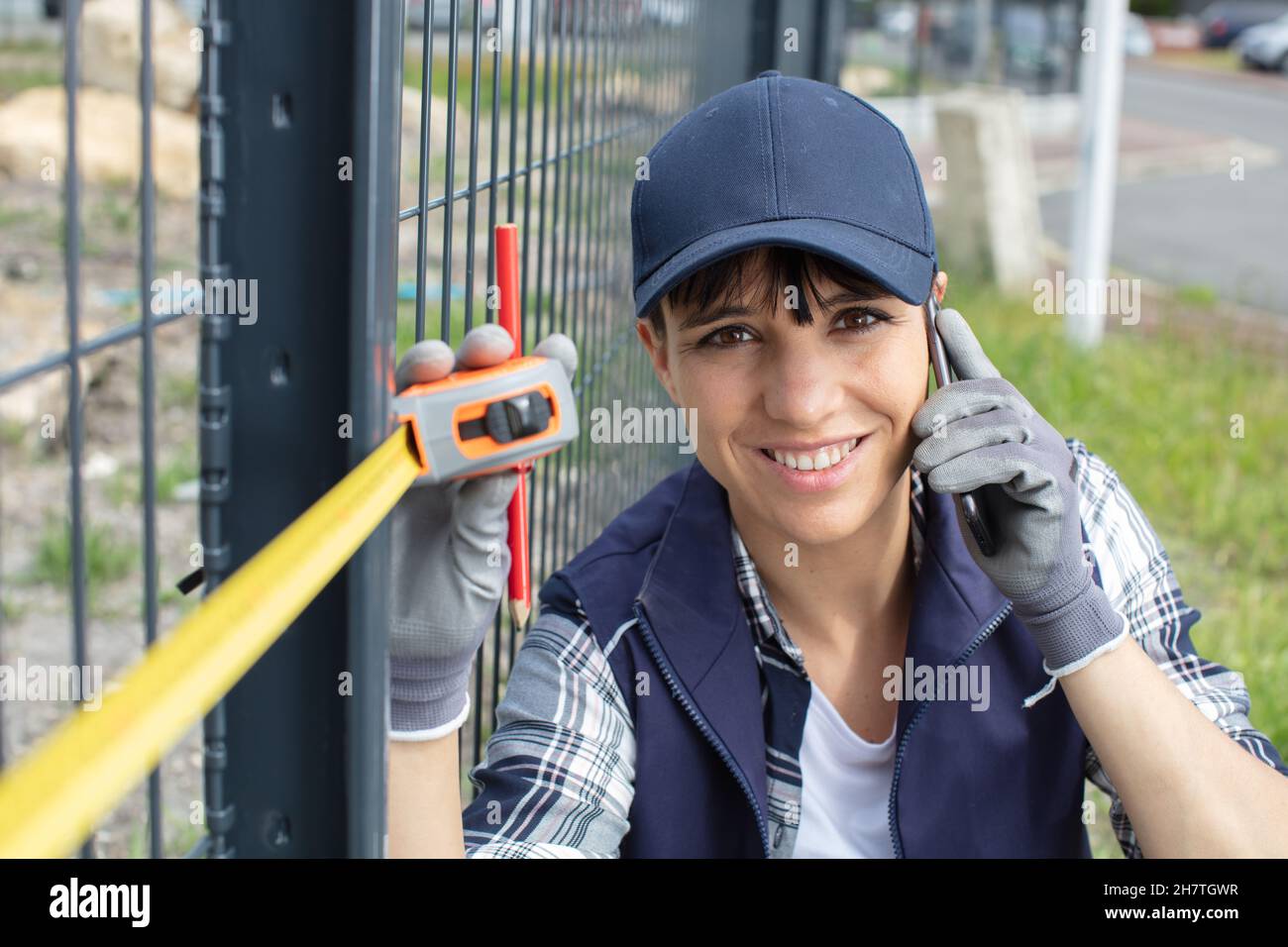 woman contractor measuring metal fence Stock Photo - Alamy