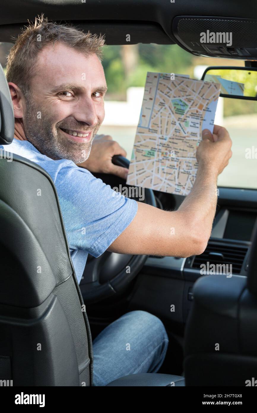 happy man with the map in the car Stock Photo - Alamy