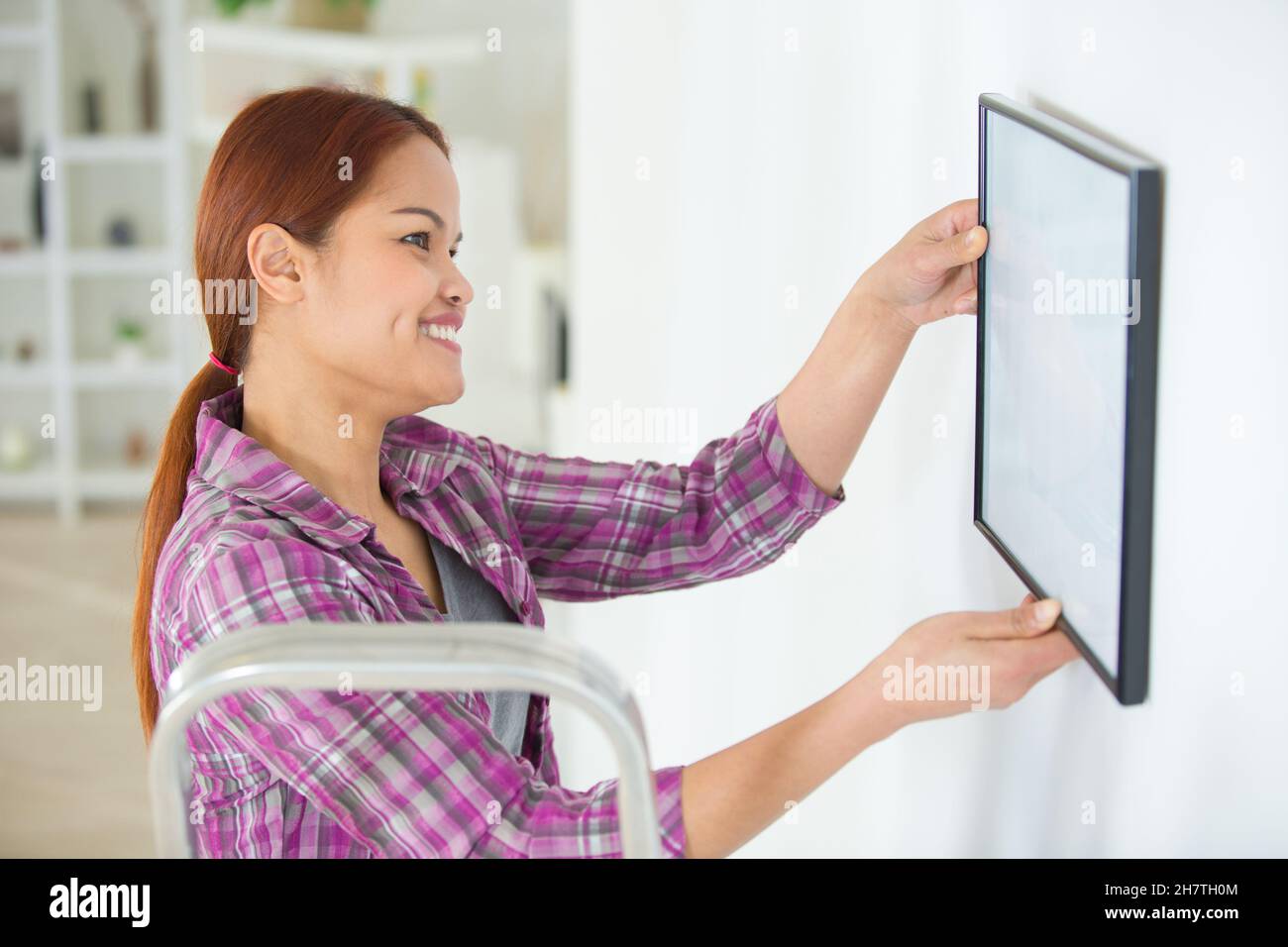concept of woman hanging picture frames Stock Photo - Alamy