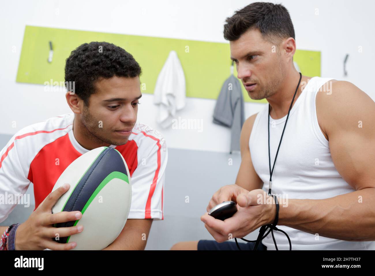 rugby coach showing stopwatch to young player Stock Photo - Alamy