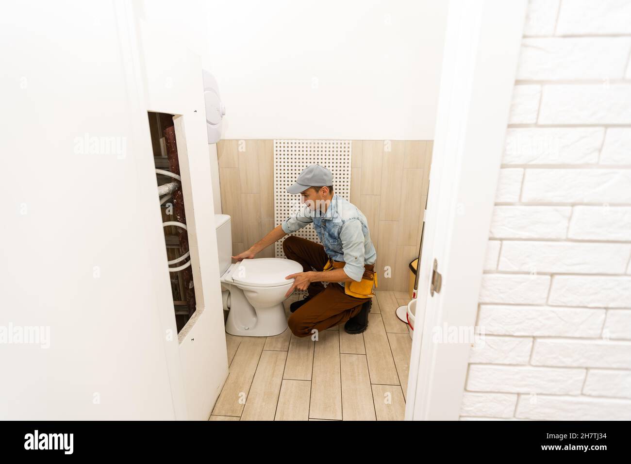 Plumber with a toilet plunger. The worker Stock Photo - Alamy