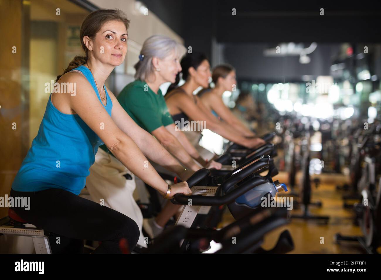 Woman riding stationary bike at fitness center Stock Photo - Alamy