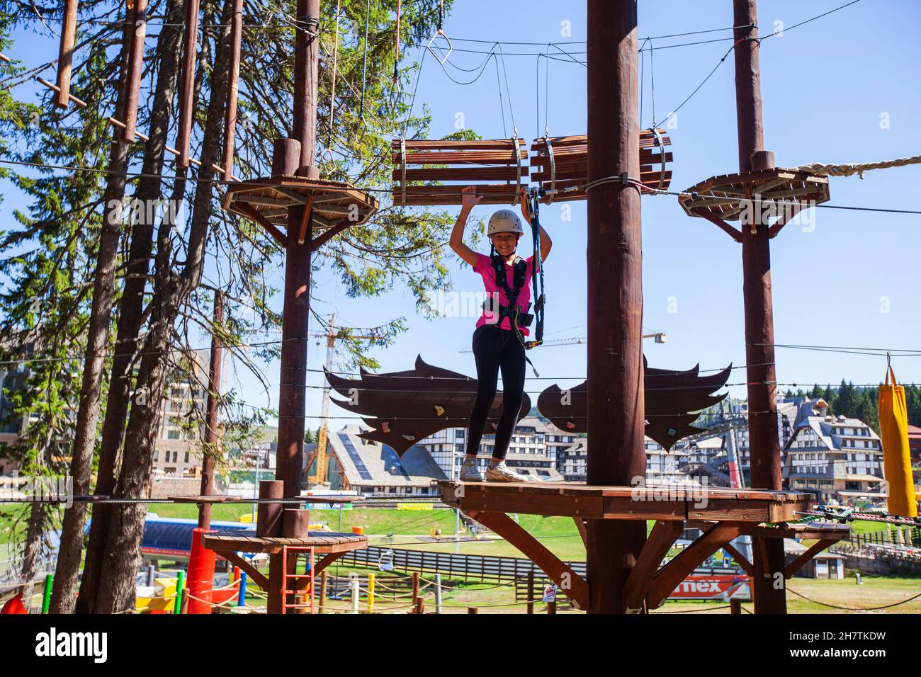 Little girl in safety equipment at adventure amusement park. Child ...
