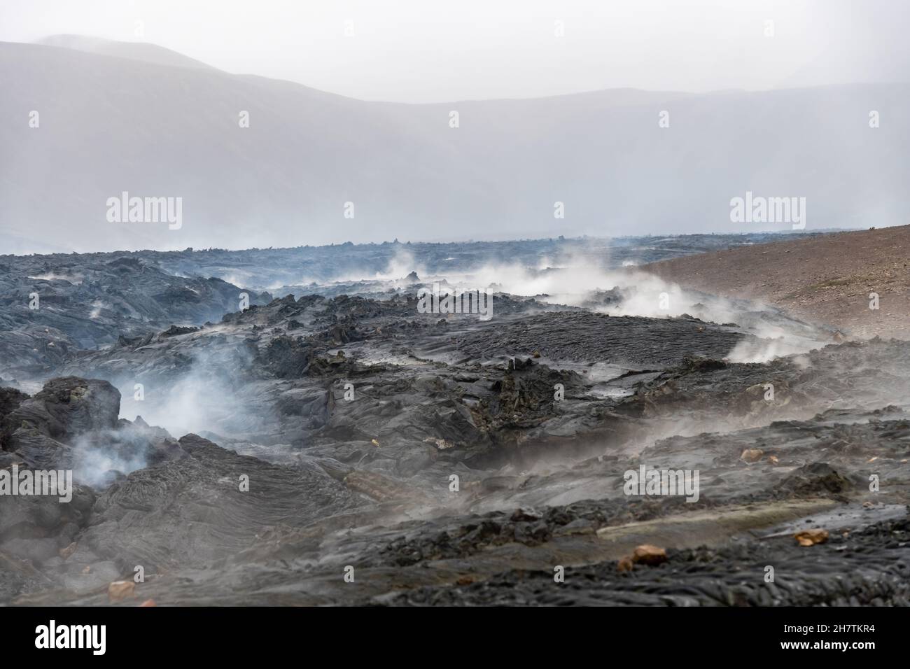 Close up view of cracked lava crust or ingenious rock and steam, cooled ...