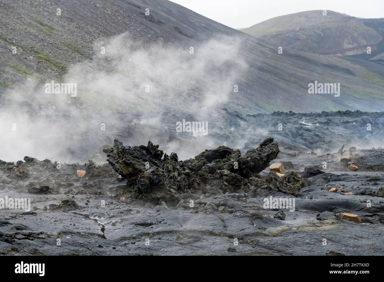Close up view of cracked lava crust or ingenious rock and steam, cooled ...