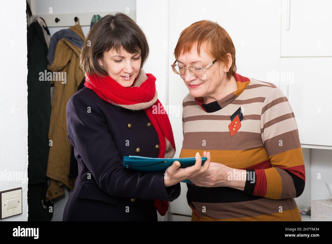 Mature woman answer questions of young employee Stock Photo - Alamy