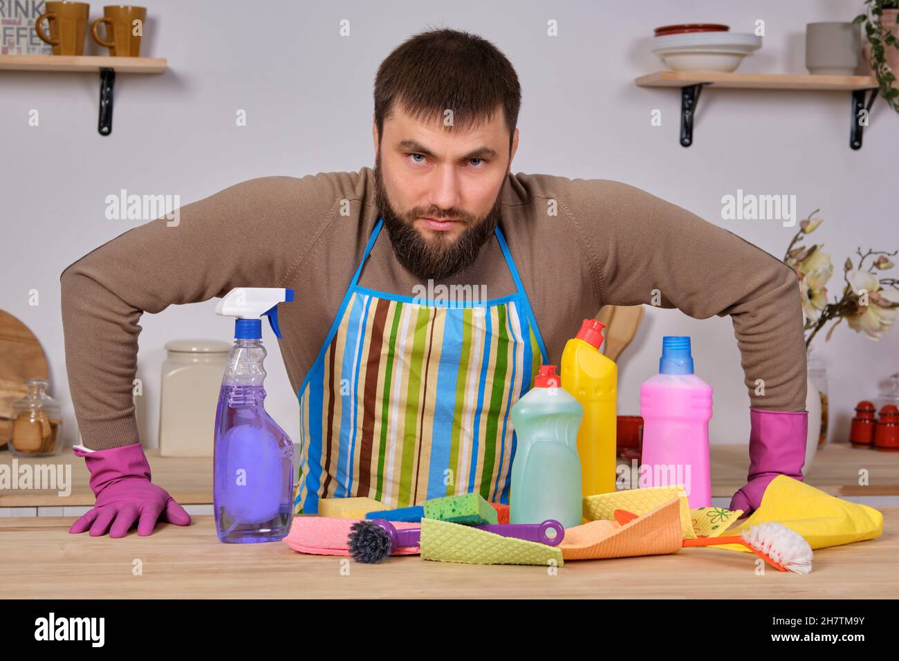 Young handsome bearded man in the kitchen, shows all his cleaning staff ...