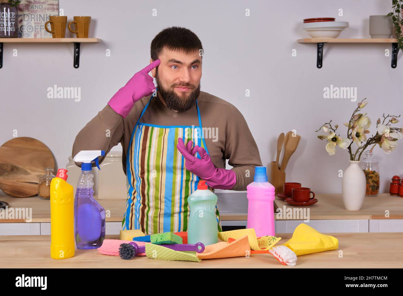 Young handsome bearded man in the kitchen, shows all his cleaning staff ...