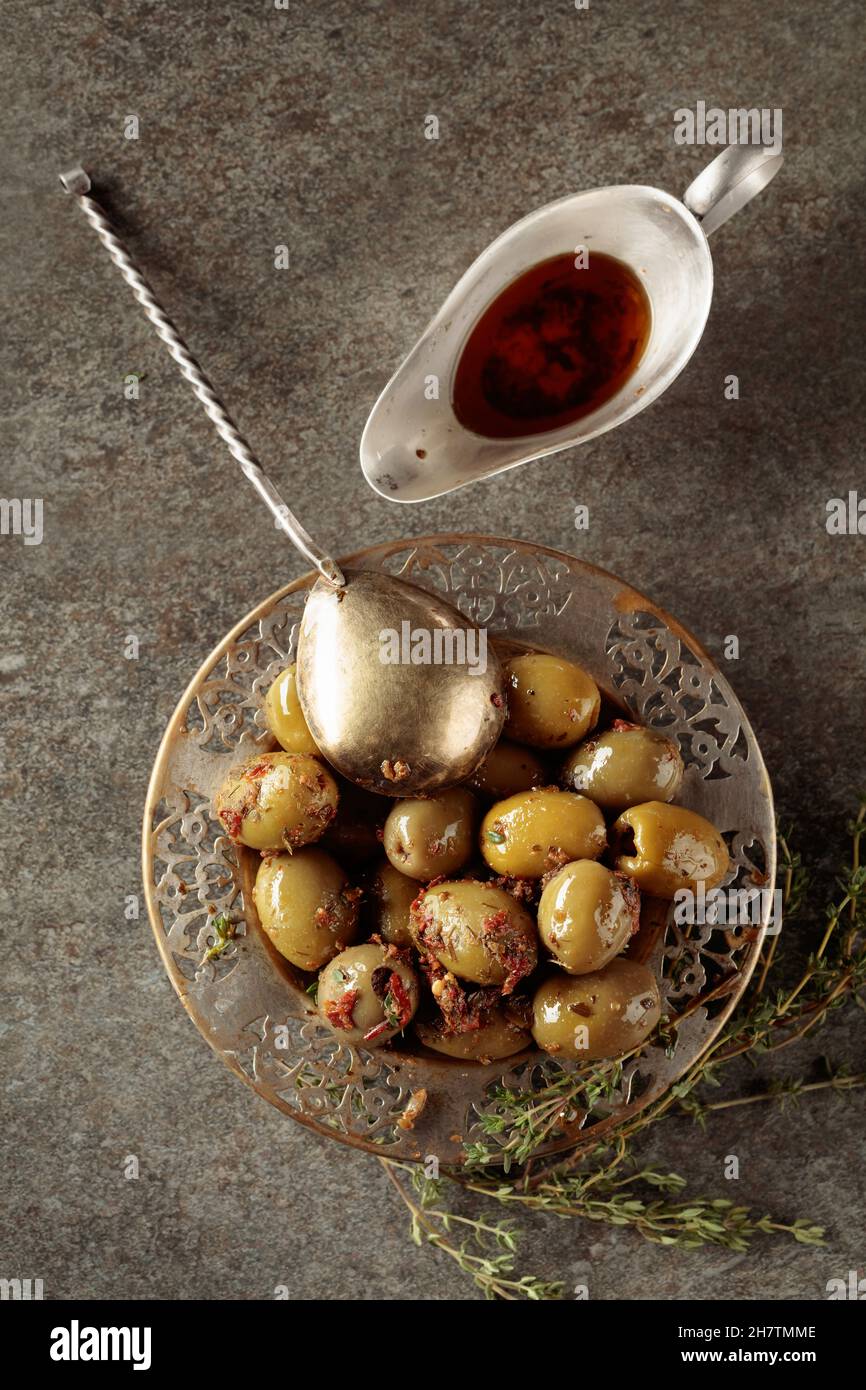 Spicy green olives in olive oil on a old stone table. Top view Stock ...