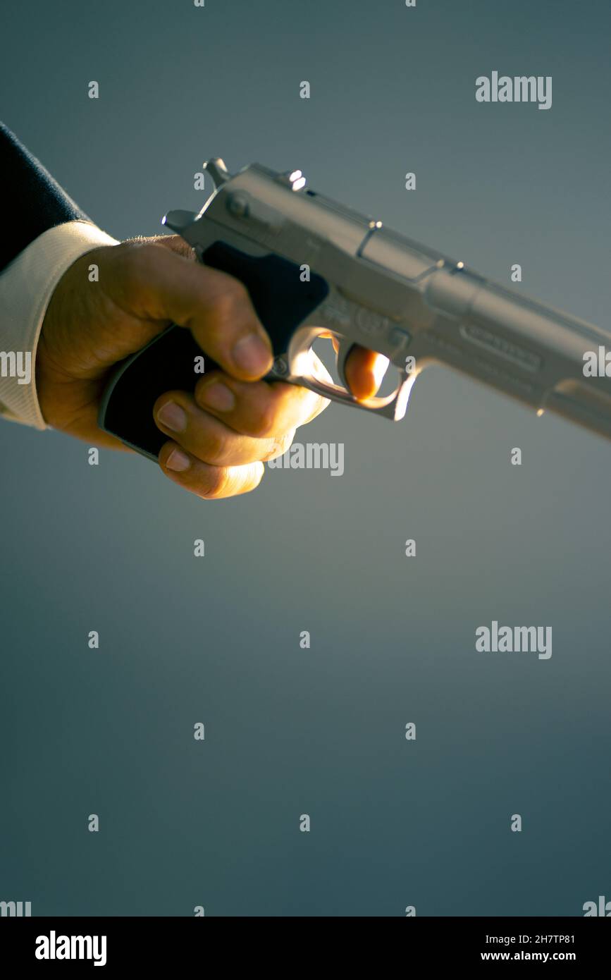 Male detective spy killer holding pistol gun in dramatic novel book ...