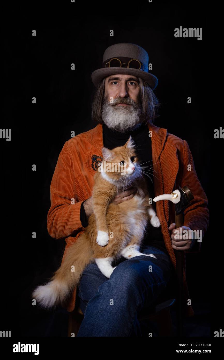 A gray-haired bearded intellectual of mature age in a steampunk hat ...