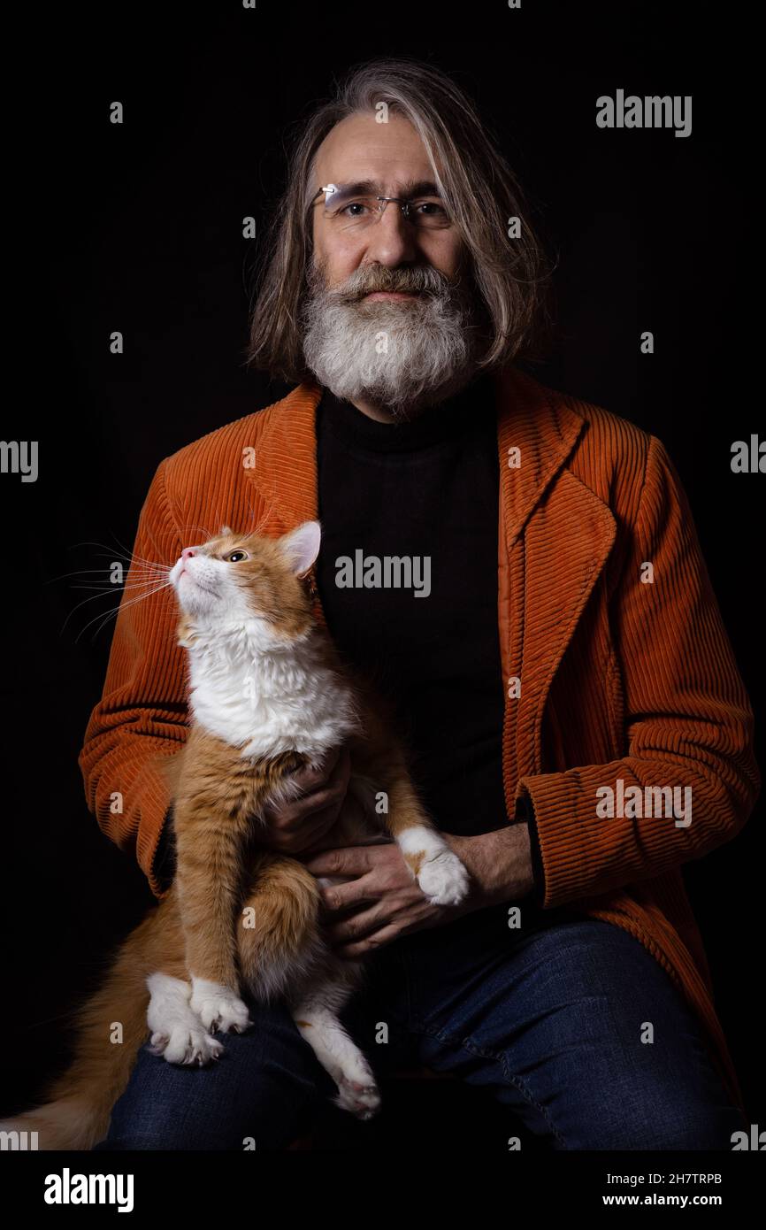Gray-haired bearded intellectual of mature age posing with a ginger ...