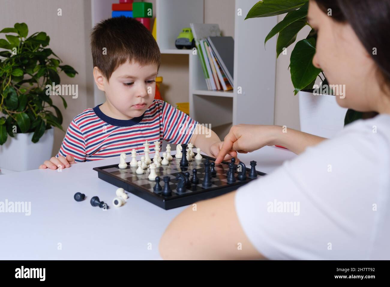 Mother and son play chess at home. Board games for preschoolers and ...