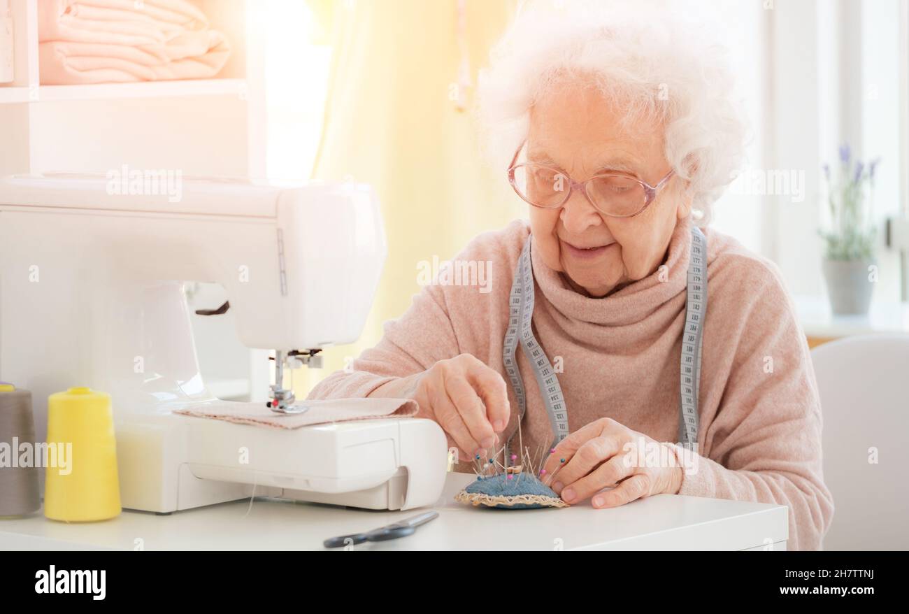 Lovely aged woman sewing Stock Photo - Alamy