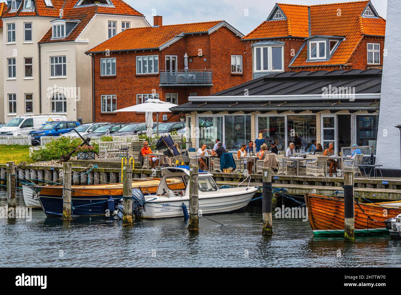 Tourists and locals having lunch in a restaurant on the quay of the ...