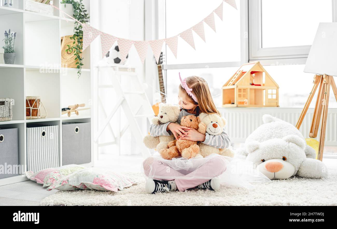 Smiling little girl hugging teddy bears Stock Photo - Alamy