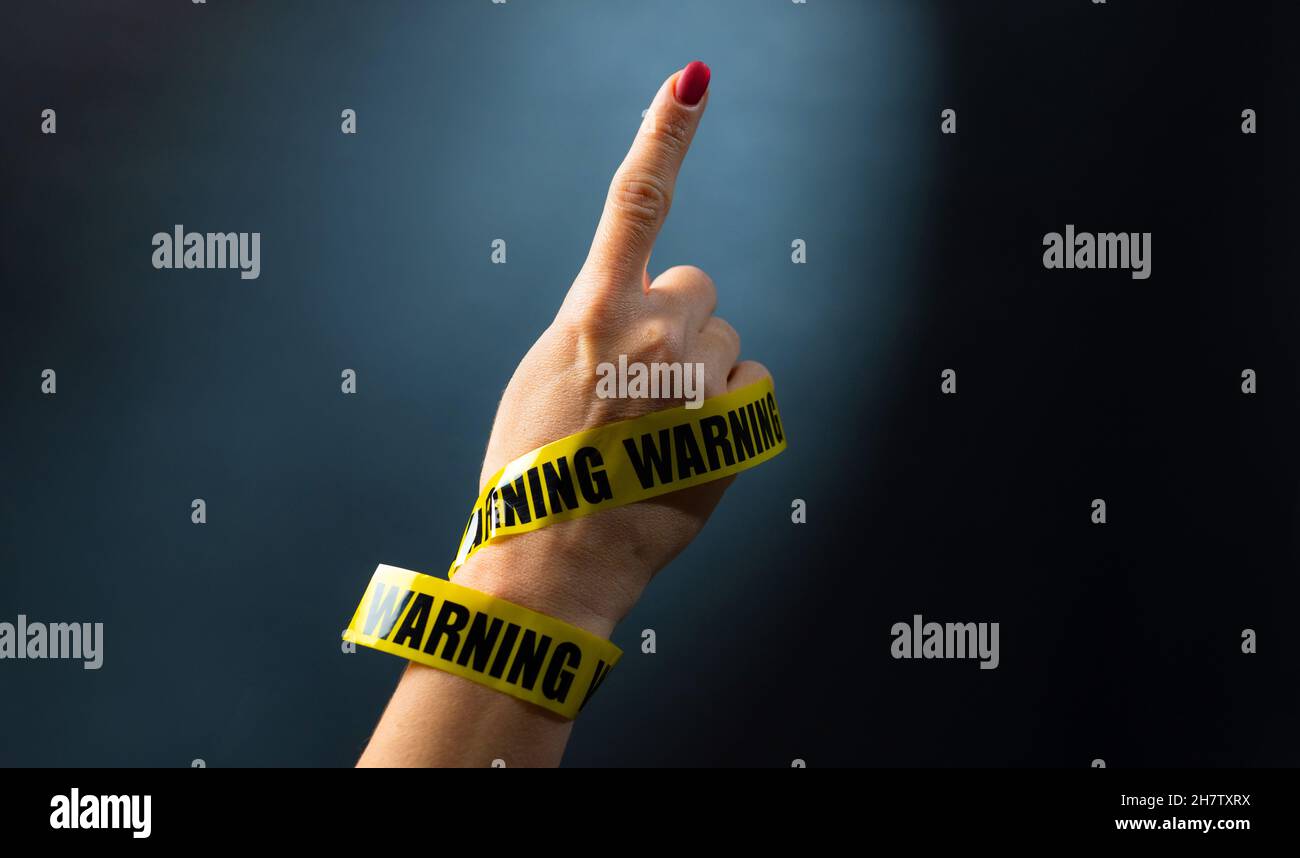 Hand with warning tape shows signs Stock Photo - Alamy
