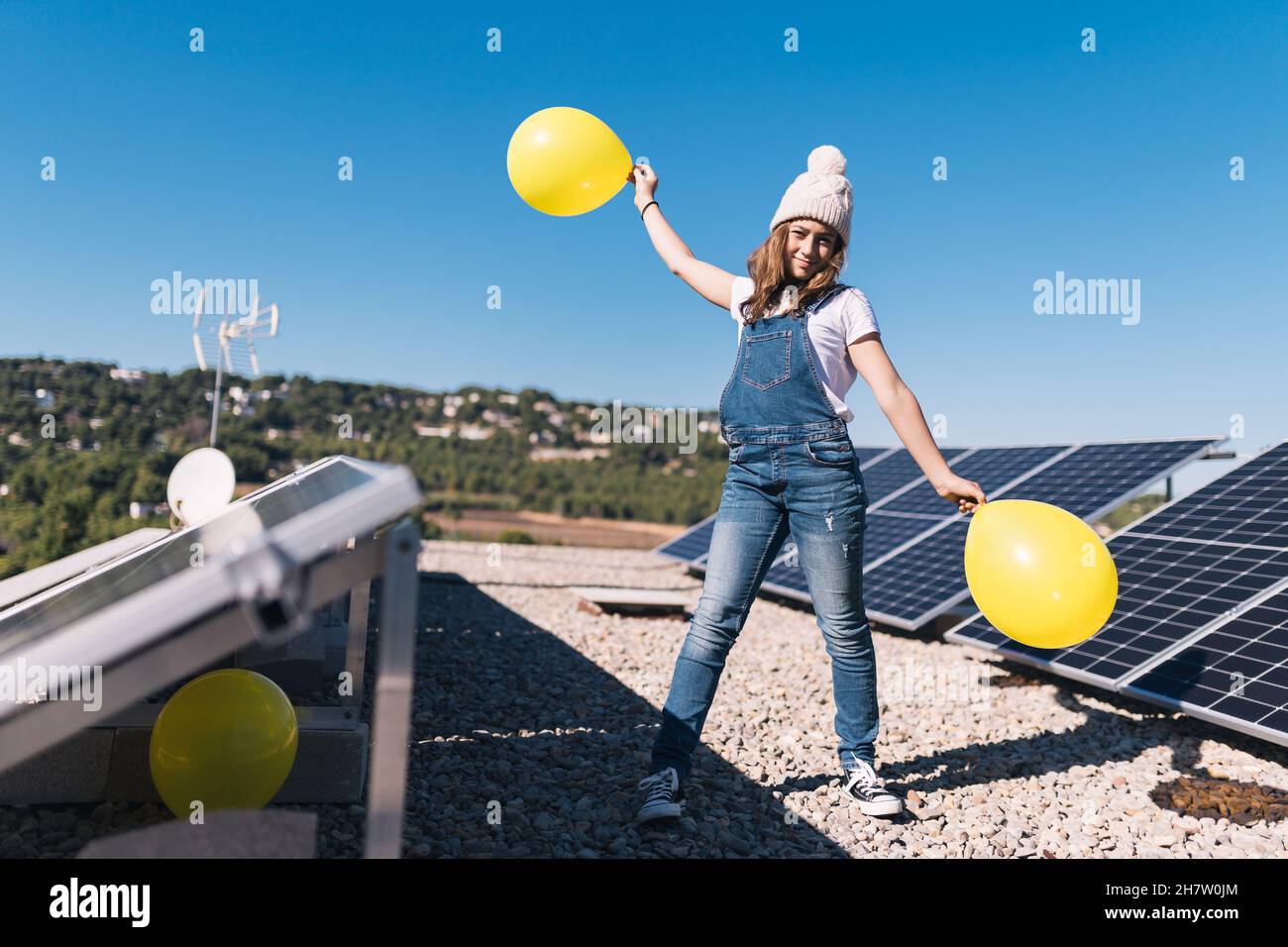Happy teenage girl on the terrace next to the solar panels. Sunny ...