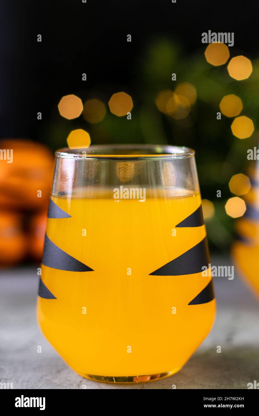 orange mandarin cocktail in glass with black stripes. Christmas holiday ...